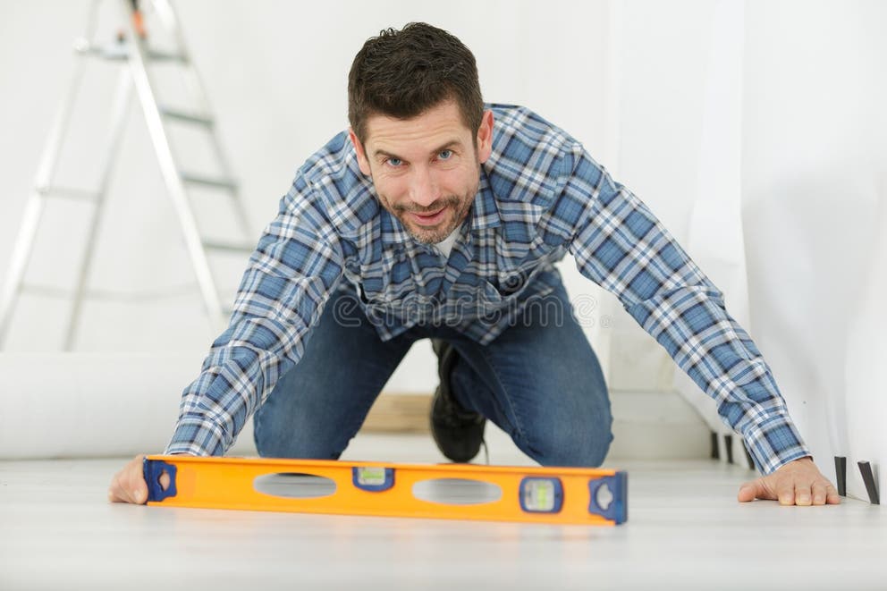 Handyman check floor level stock photo. Image of laminate - 271107948