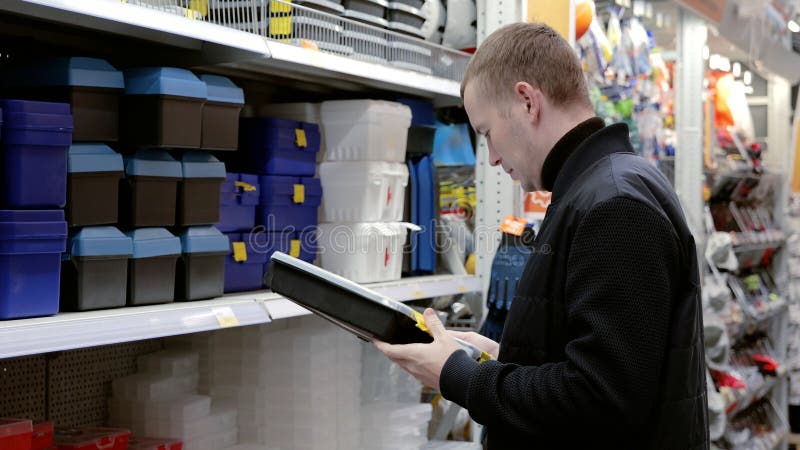 Handyman is Choosing a Toolbox in a Hardware Store, Standing in the ...