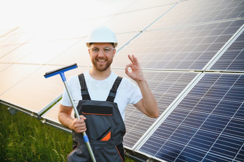 A Handyman Cleaning Solar Panels Form Dust and Dirt. Stock Photo ...
