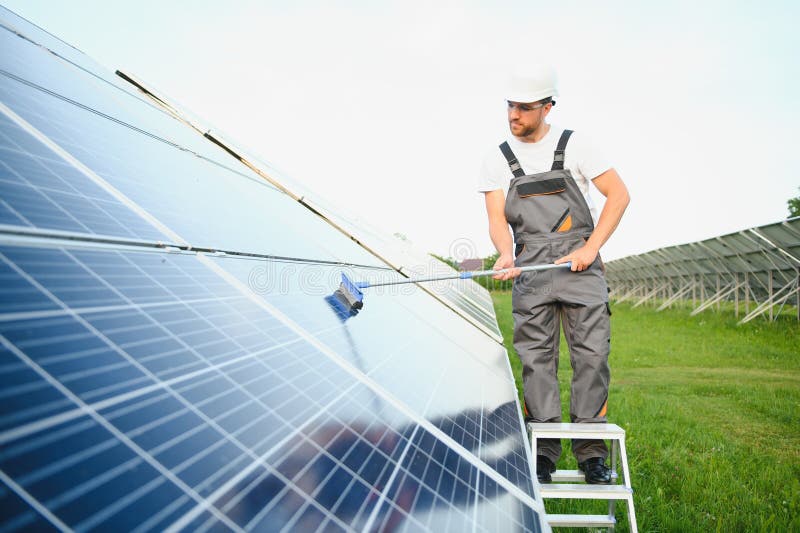 A Handyman Cleaning Solar Panels Form Dust and Dirt. Stock Photo ...