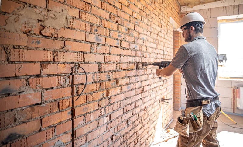 A Builder Works with a Drill at a Construction Site Stock Photo - Image ...