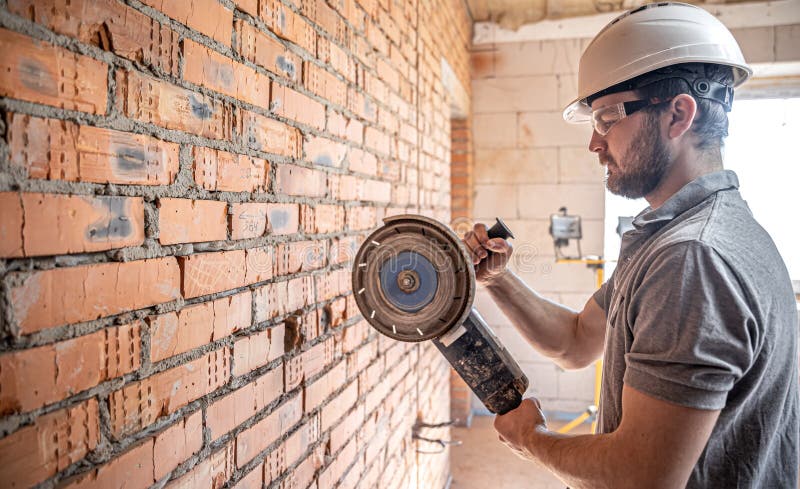 A Handyman at a Construction Site Works As a Grinder Stock Photo ...
