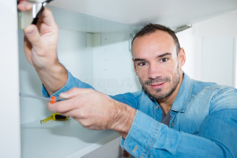 Handyman fixing a wardrobe stock photo. Image of fitted - 171375072
