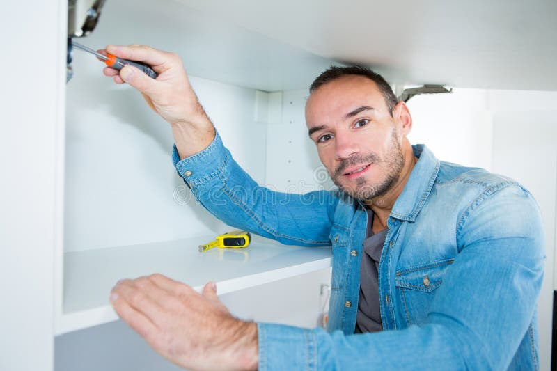 Handyman fixing wardrobe stock photo. Image of preparation - 326233352