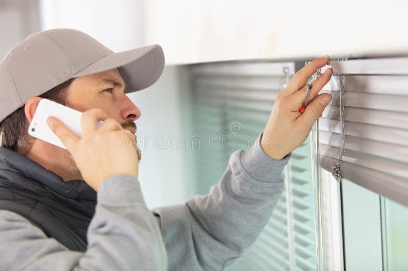 Handyman Installing Window Blinds Makes Telephone Call Stock Image ...