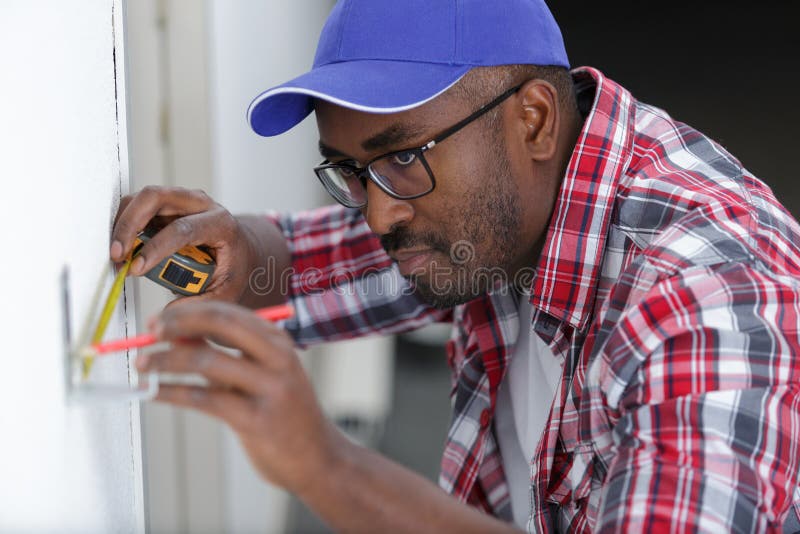 Handyman Measuring Wall at Construction Site Stock Image - Image of ...