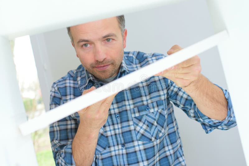 Handyman putting up shelf stock image. Image of building - 83783319