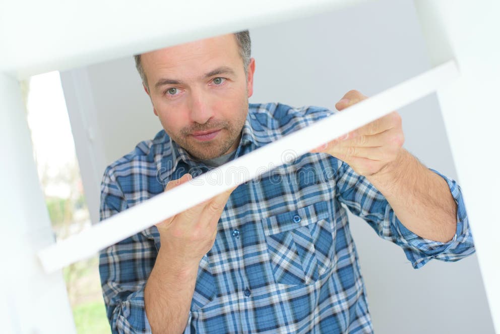 Handyman putting up shelf stock image. Image of building - 83783319