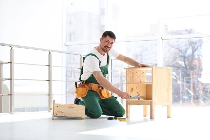 Handyman in Uniform Assembling Furniture. Professional Construction ...
