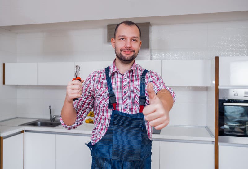 Handyman in Uniform Standing Next To the Toolbox in the Kitchen Stock ...