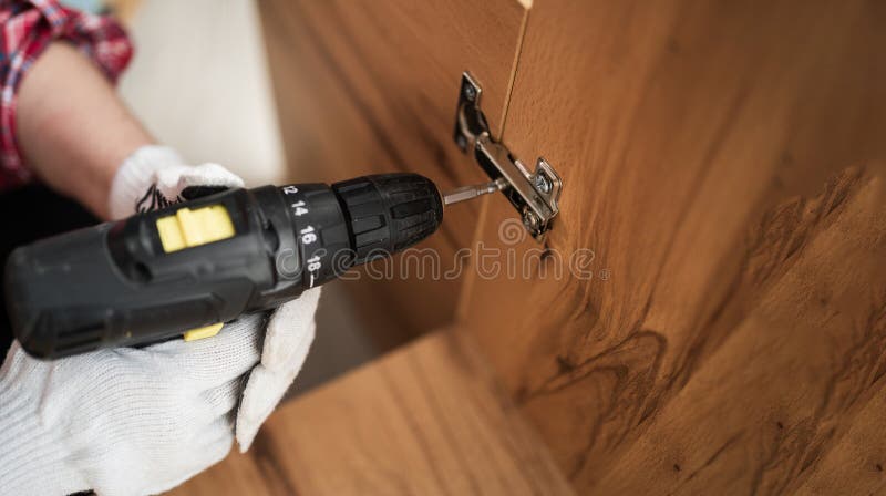 Handyman Using Electric Drill for Fixing Hinges while Doing Furniture ...