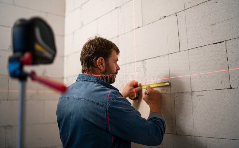 Handyman Working on Construction Site, Measuring Wall. Stock Image ...