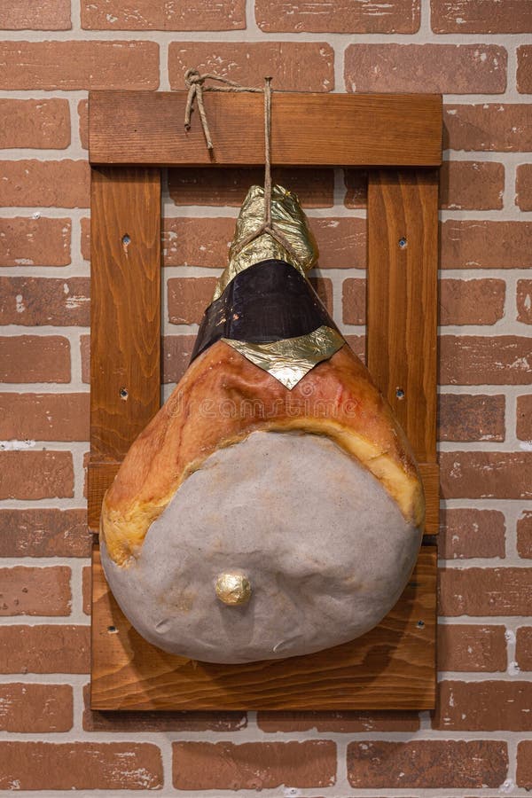 Hanging Raw Parma Ham Leg in Front of a Wall with Exposed Brickwork ...