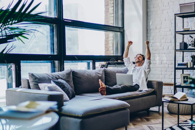 Happy Accomplished Man Resting on Sofa and Celebrating Victory Stock ...