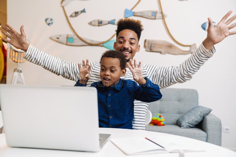 Happy African American Father And Son Making Fun While Using Laptop