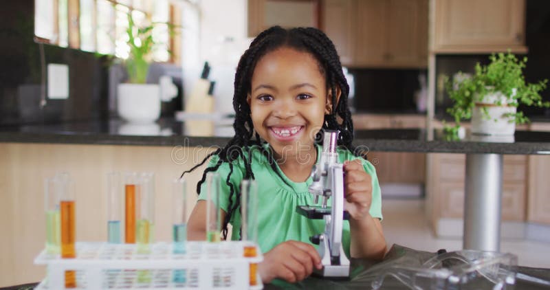 Happy African American Girl Using Microscope, Doing Experiments at Home ...