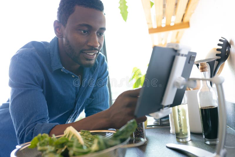 Happy African American Man Cooking Dinner in Kitchen, Using Tablet ...