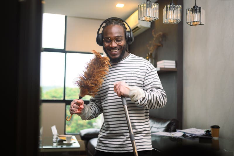 Happy African American Man Having Fun Cleaning House and Singing Using ...