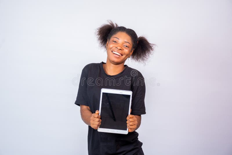 Happy African Lady Holding a Tablet Computer with the Screen Facing ...