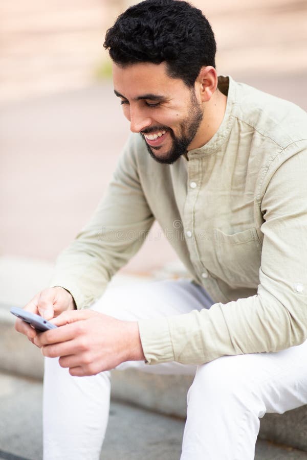 Happy Arab Guy Sitting Outside Using His Mobile Phone Stock Photo ...