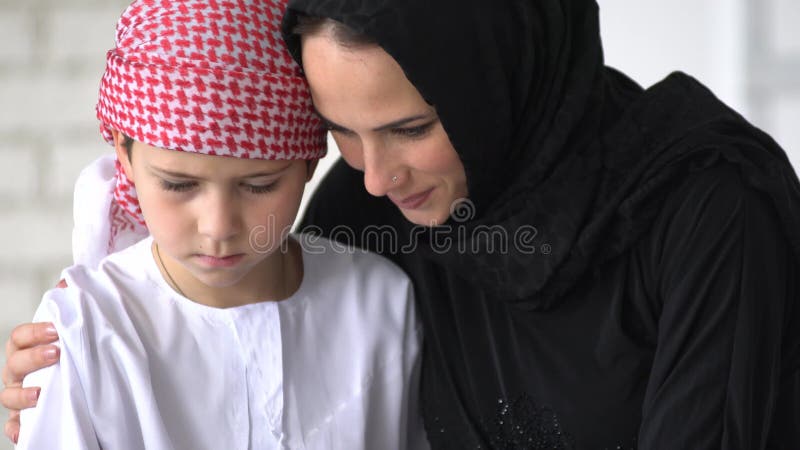 Happy Arabic Mother and Son Together Sitting on the Couch and Reading a ...