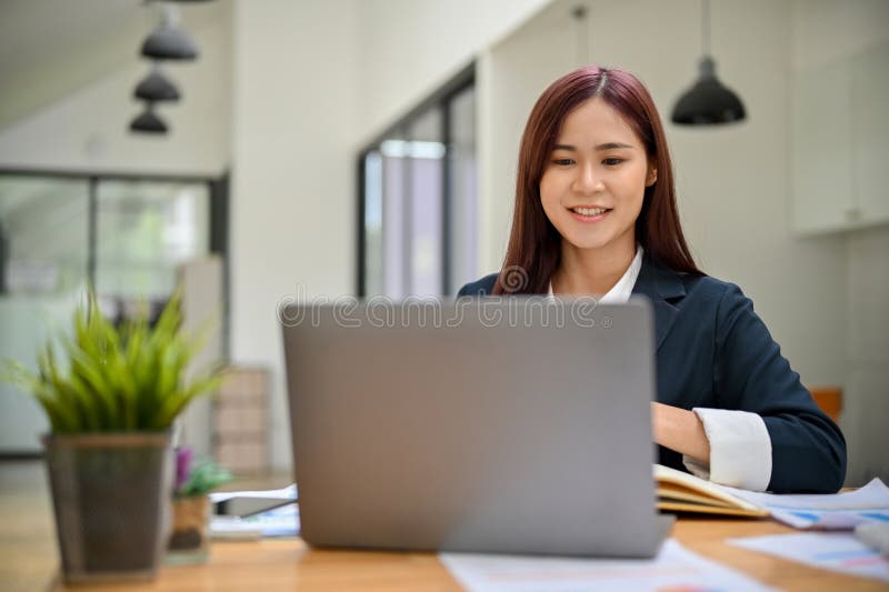 Happy Asian Businesswoman Sits at Her Office Desk, Using Laptop ...