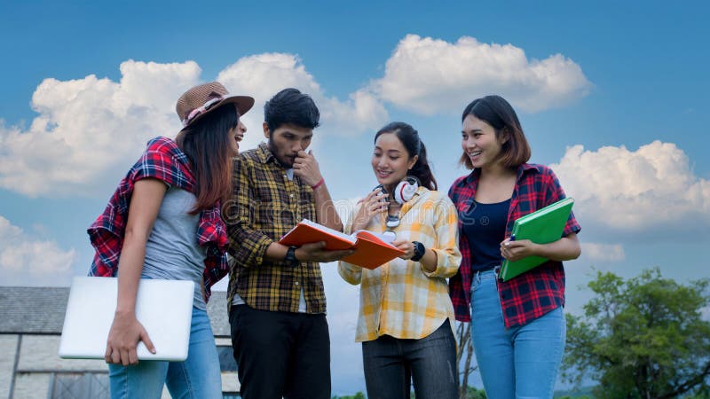 Happy Asian Group of Students Talking and Holding Notebooks Outdoors ...