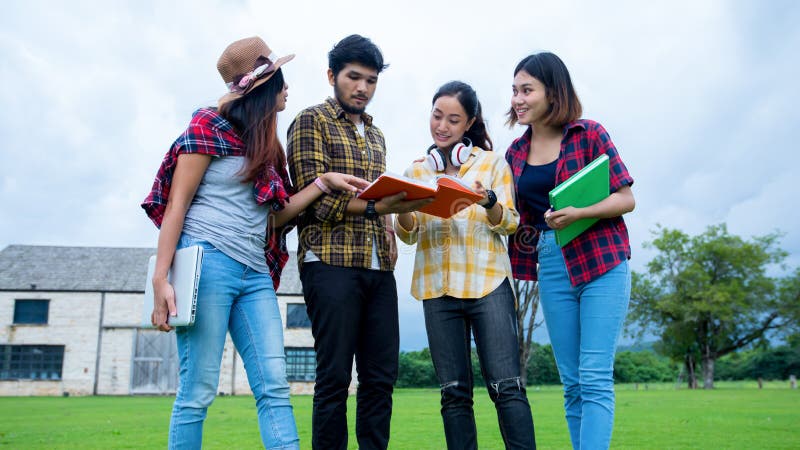 Happy Asian Group of Students Talking and Holding Notebooks Outdoors ...