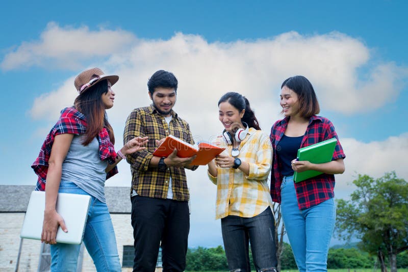 Happy Asian Group of Students Talking and Holding Notebooks Outdoors ...