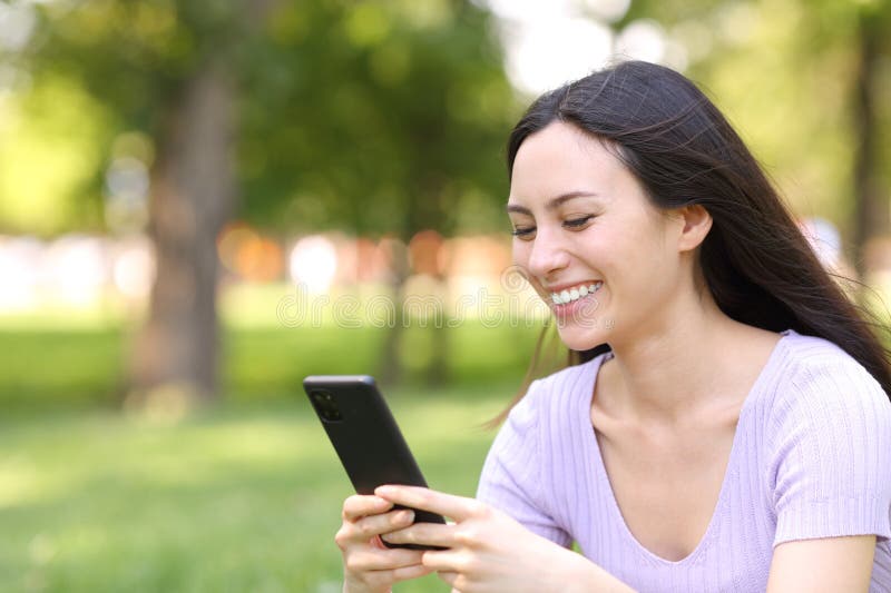 Happy Asian Woman Checking Cell Phone in a Park Stock Photo - Image of ...