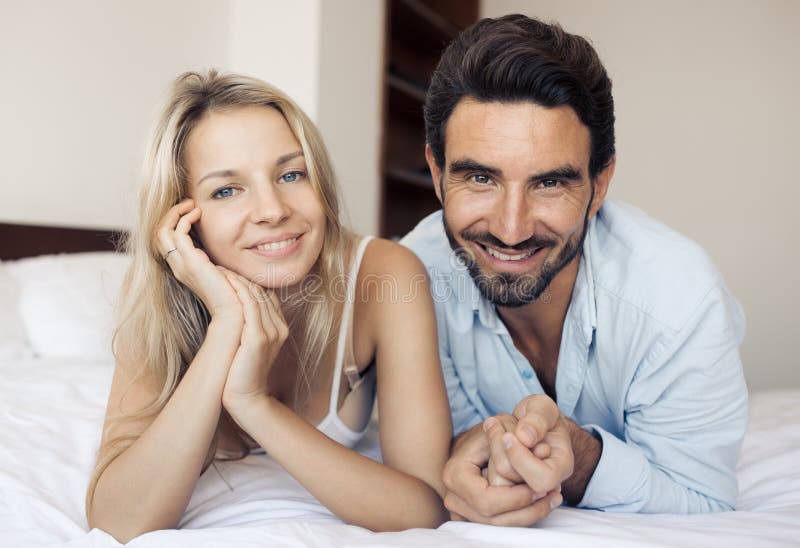 Happy Attractive Smiling Couple Lying on Bed in Bedroom Stock Photo ...