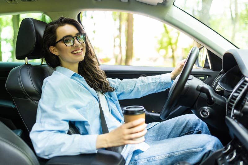 Happy Attractive Woman Driving a Car while Drinking Coffee Stock Photo ...