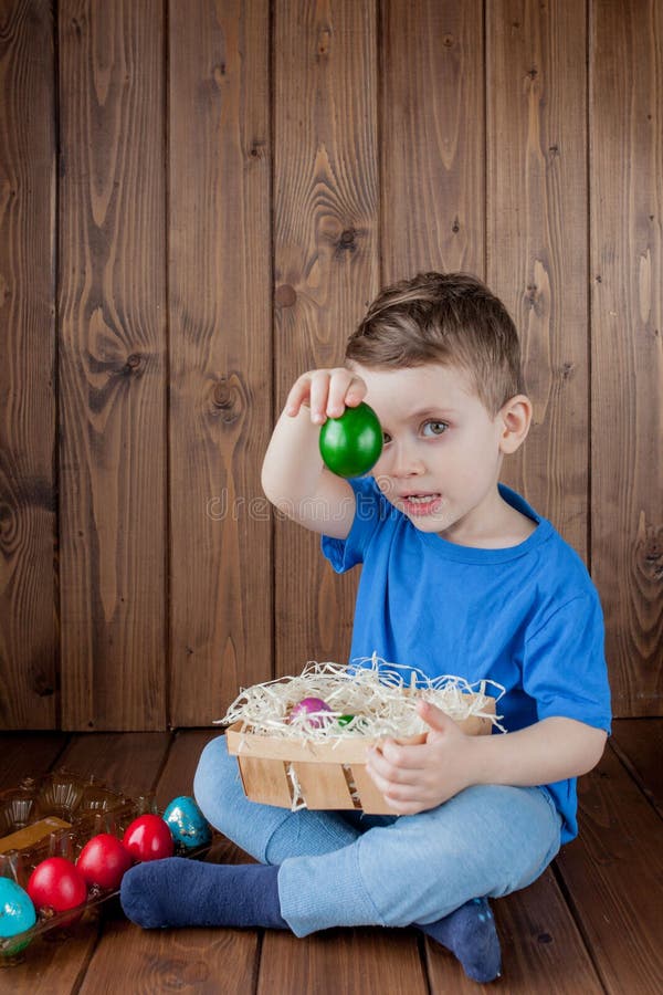 Happy Baby Boy with a Basket of Easter Eggs on Wooden Background Stock ...
