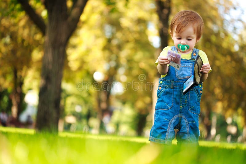 Happy Baby Playing with a Wallet in the Green Park Stock Image - Image ...