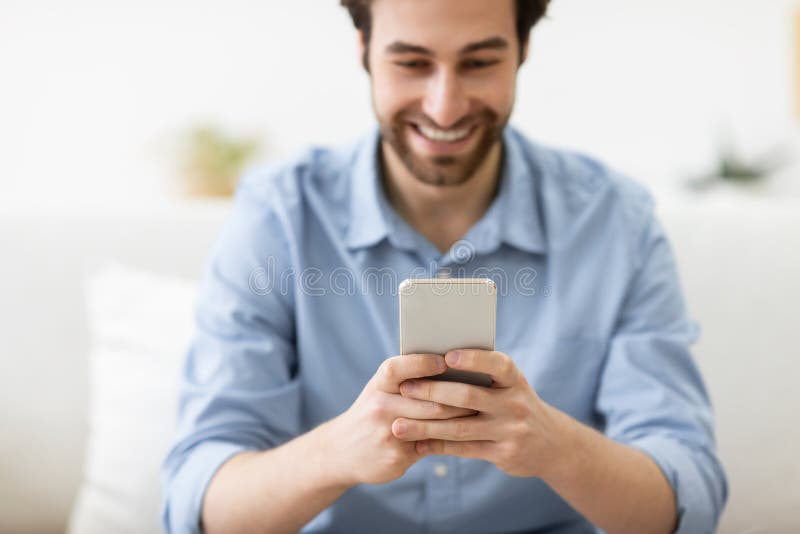 Happy Guy Using Smartphone Texting Sitting on Couch at Home Stock Image ...
