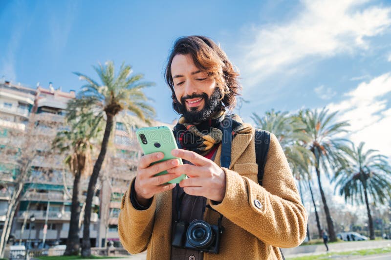 Happy Bearded Man Using a Cellphone App for Browsing on Internet ...