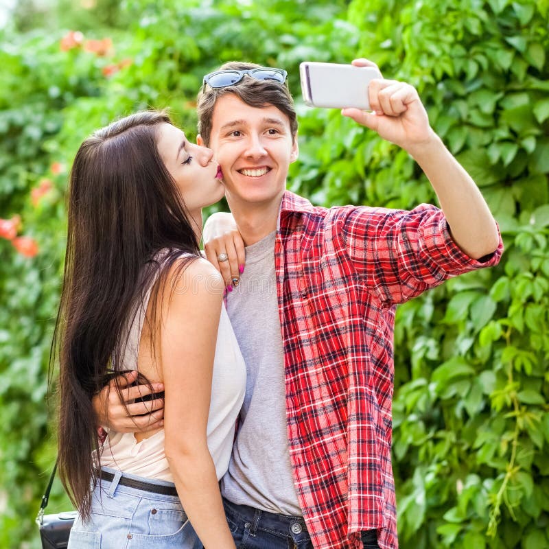 Happy Beautiful Couple Taking A Selfie On A Mobile Phone Huging And
