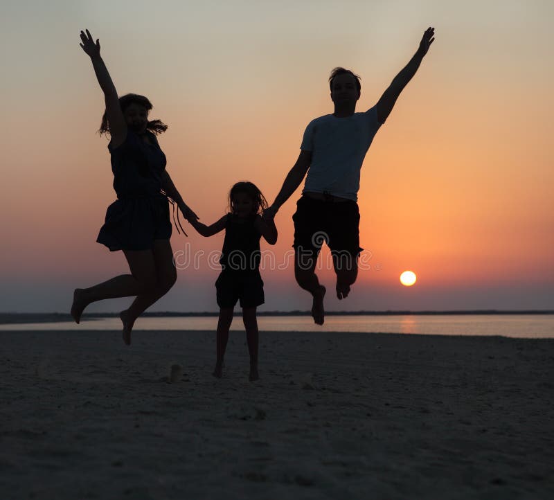 Happy Beautiful Family Jumping on the Beach at the Sunset Stock Photo ...
