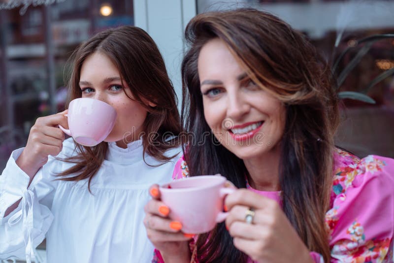 Happy Beautiful Ladies Sitting Together Outdoors In Cafe And Enjoying