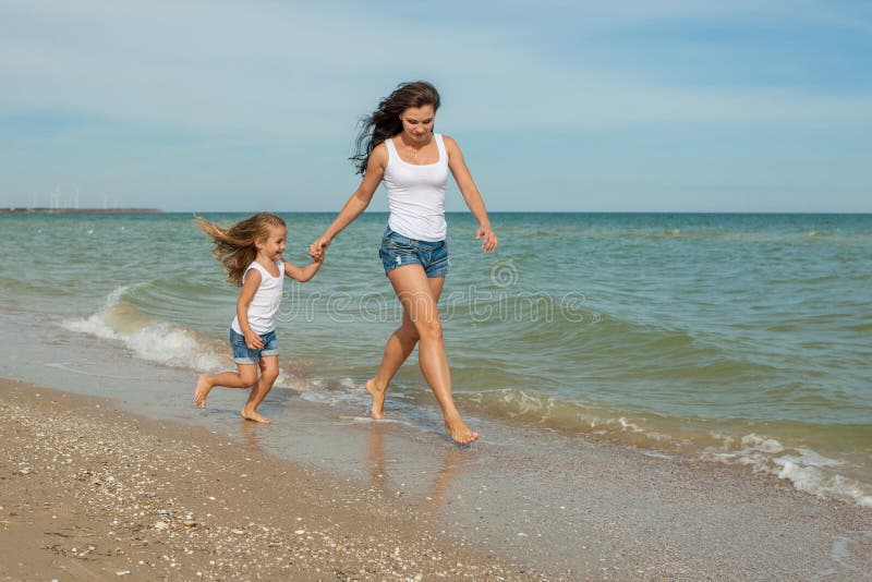 Happy Beautiful Mother And Daughter Enjoying Beach Time Stock Image