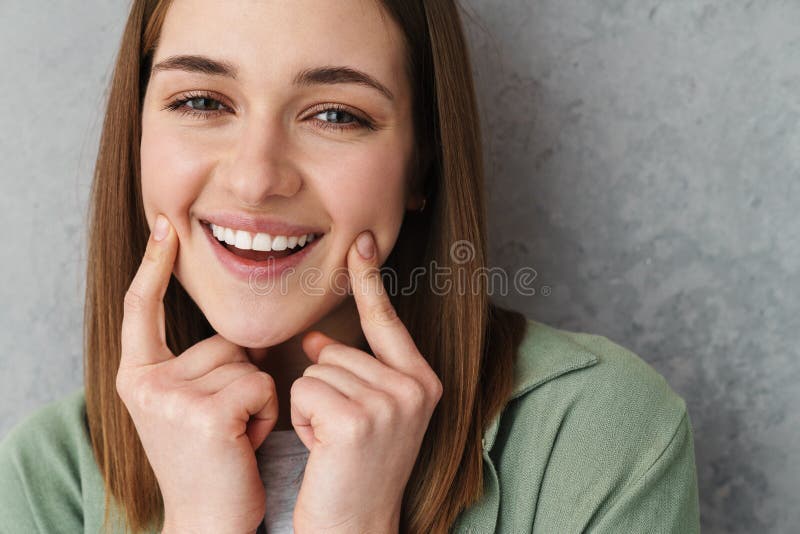 Happy Beautiful Nice Girl Smiling and Pointing Fingers at Her Cheeks ...