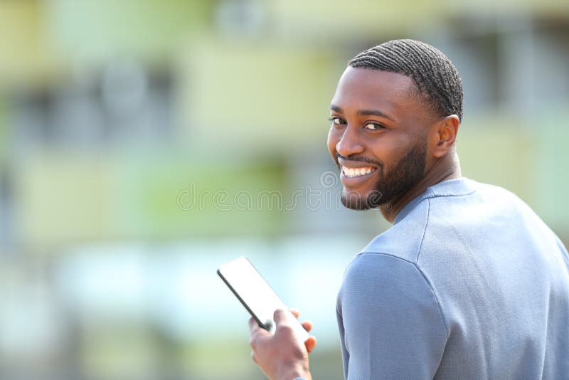Happy Black Man Holding Phone Looking at Camera Stock Photo - Image of ...