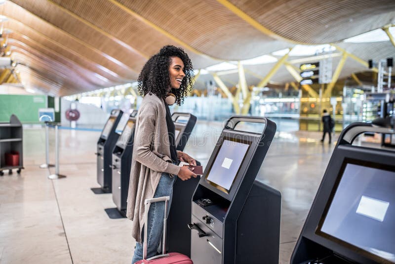 Happy Black Woman Using the Check-in Machine at the Airport Getting the ...