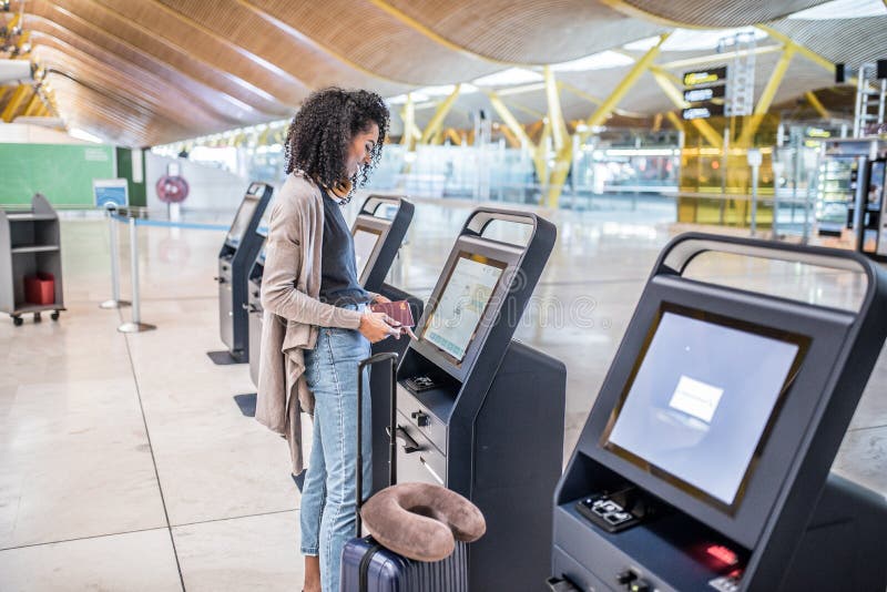 Happy Black Woman Using the Check-in Machine at the Airport Getting the ...