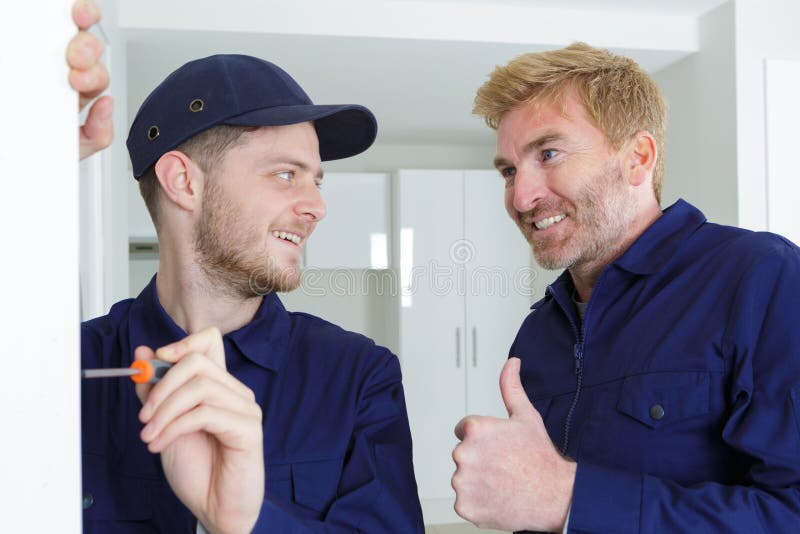 Happy Boss and Smiling Young Carpenter Install Door Lock Stock Photo ...