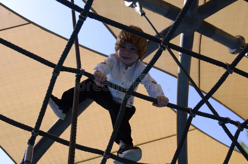 Happy Boy Cheering while Climbing a Net during Obstacle Course in Boot ...