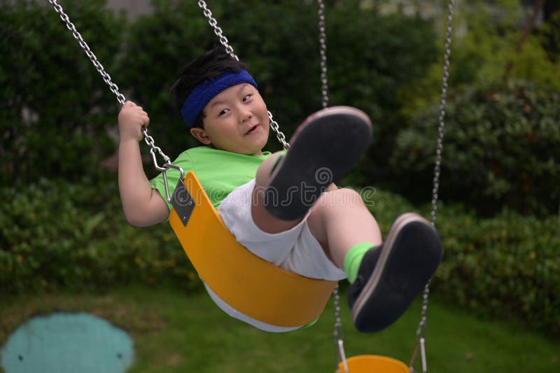 A Boy with a Headband Have a Ride on a Swing Stock Photo - Image of ...