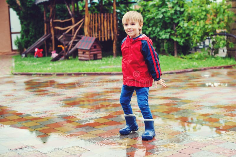 Happy Boy Jumping in Puddles after Rain. Stock Image - Image of ...