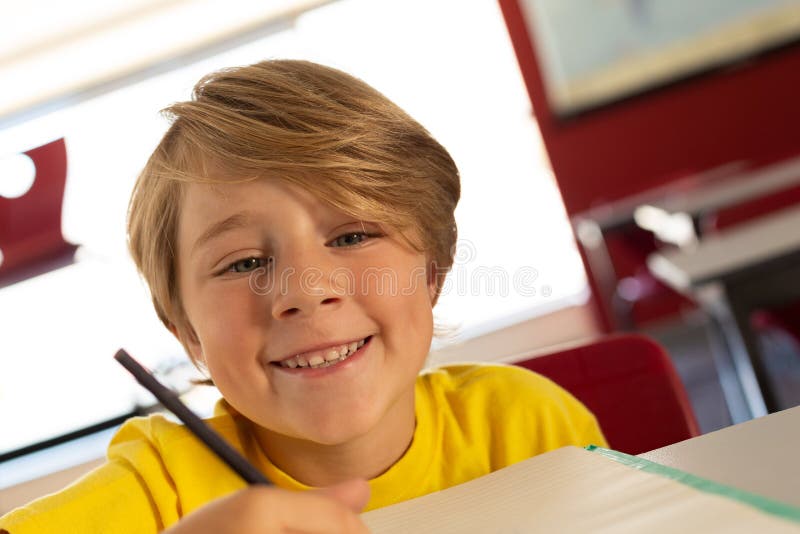 Happy Boy Looking at Camera while Drawing Sketch on Book at Desk in a ...
