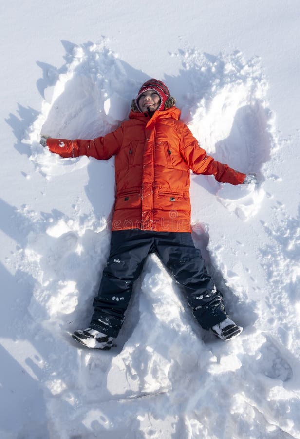 Happy Boy Lying on Snow and Making Snow Angel Figure with Hands and ...